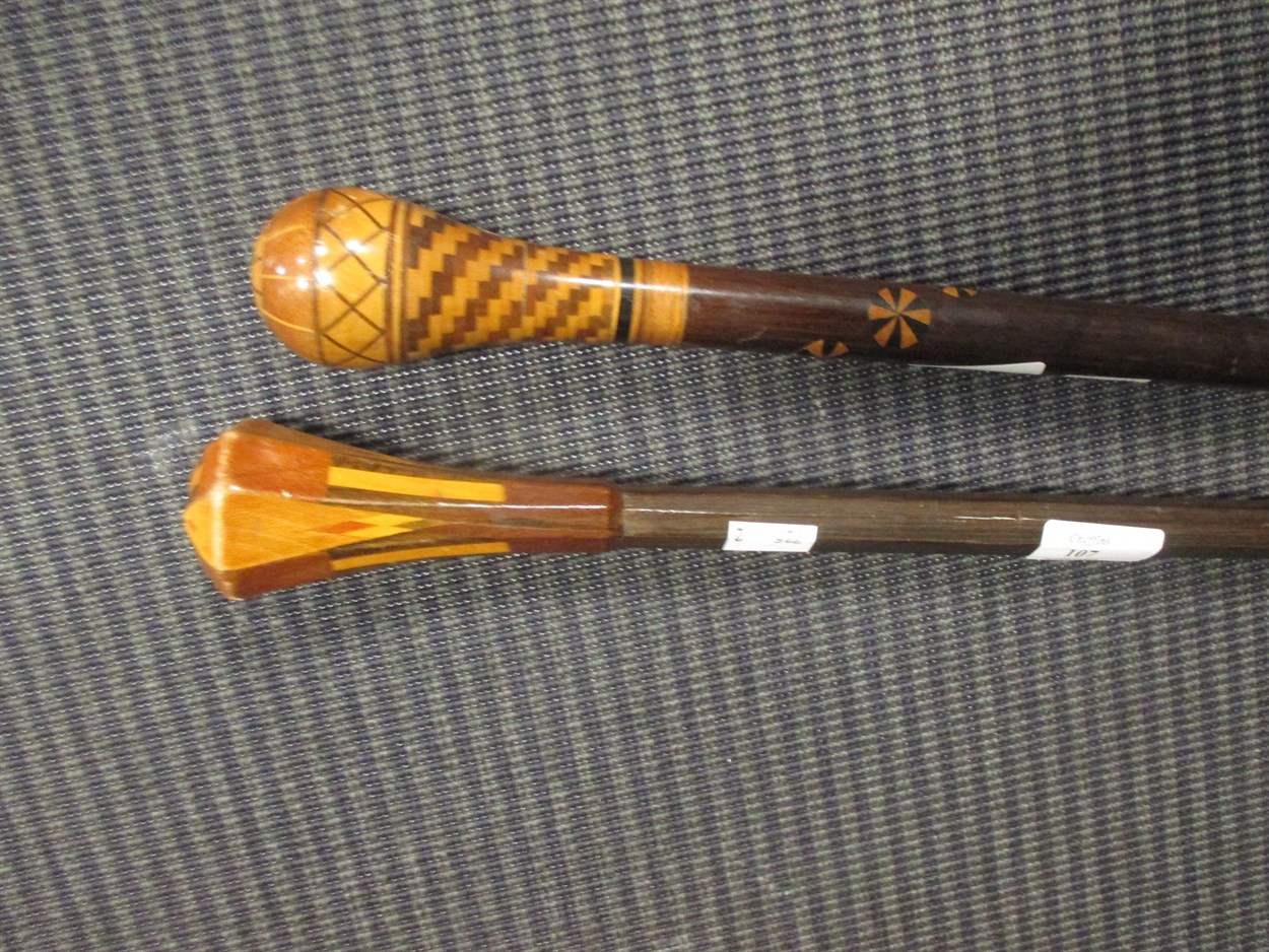 Lot 107 - Two similar inlaid wood walking sticks,