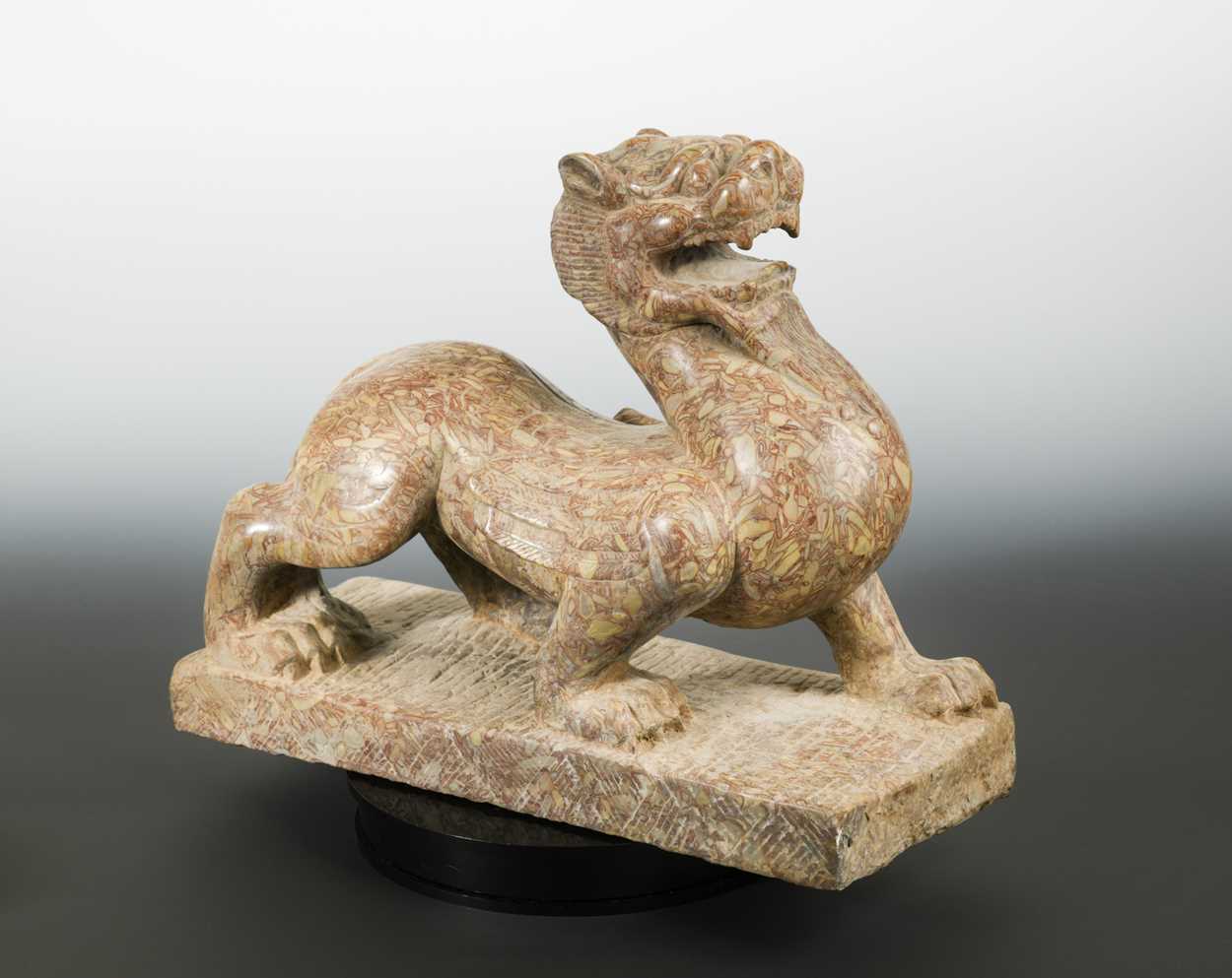 Lot 150 - A red pudding stone carving of a Crouched