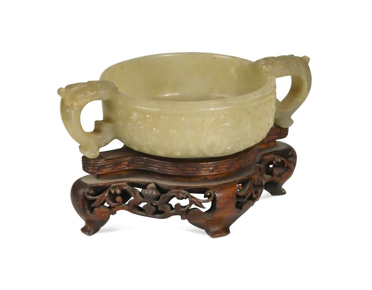 Lot 69 - A Chinese jade tab-handled bowl in an archaic