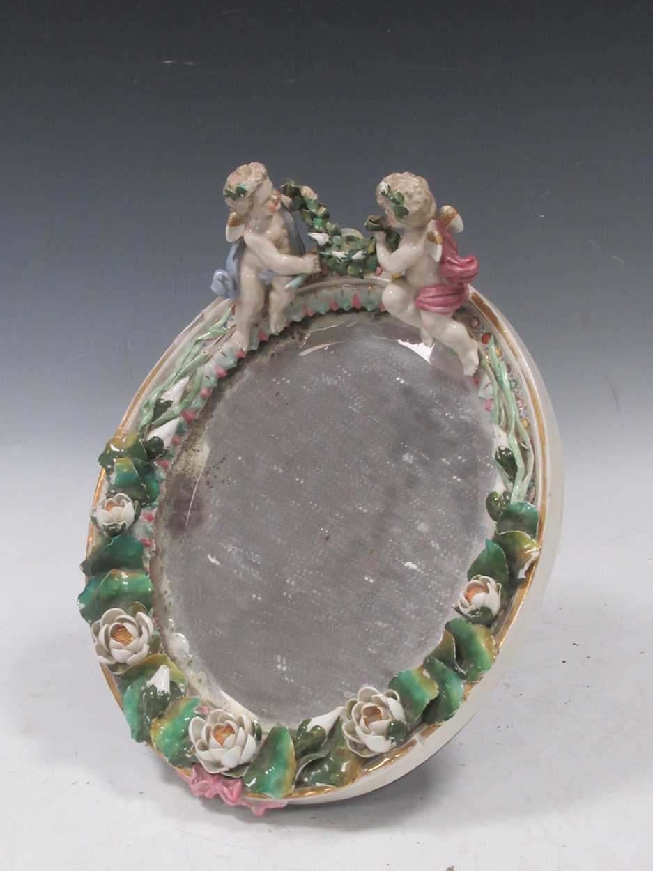 Lot 112 - A Dresden ceramic oval wall mirror, circa