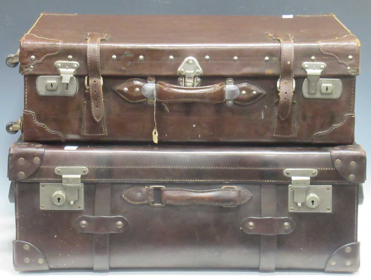 Lot 76 - Two large leather strapped suitcases in dark
