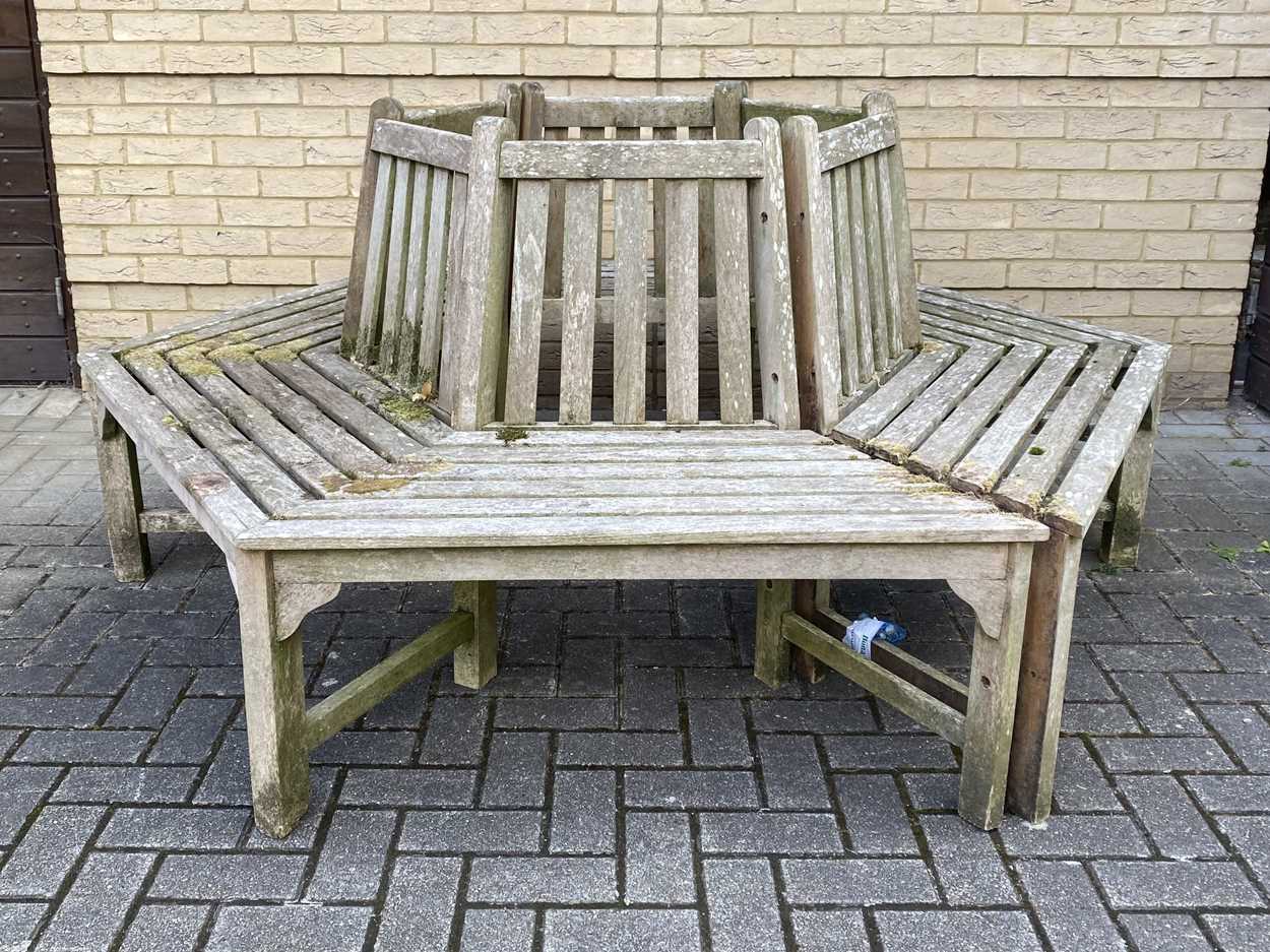 Lot 424 - Teak hexagonal tree bench with slated back