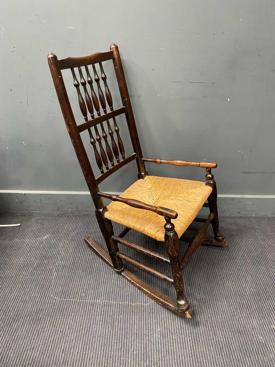 Lot 427 - An spindle back rocking chair with rush seat