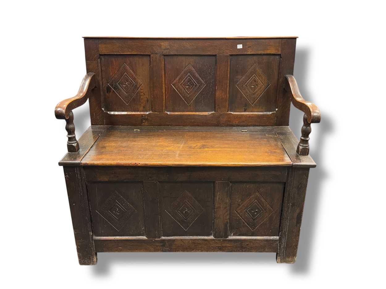 Lot 686 - An oak box settle with lozenge carved panels