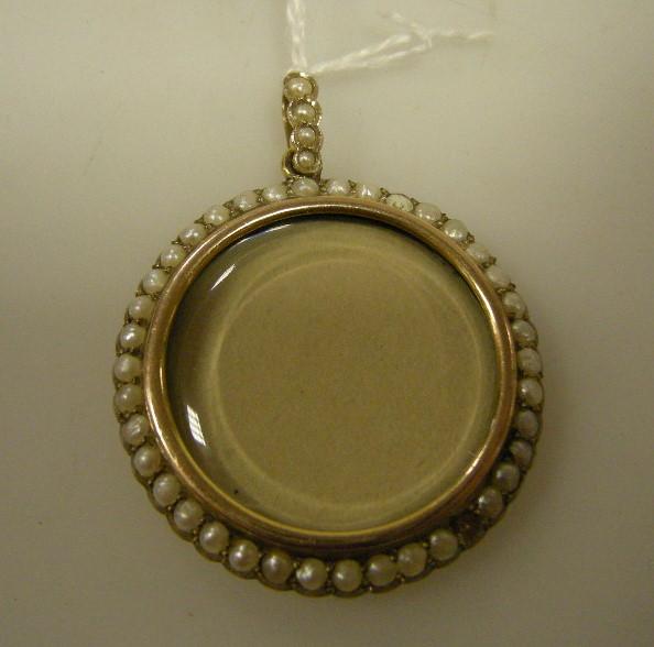 Lot 565 - A circular locket with pearl border
