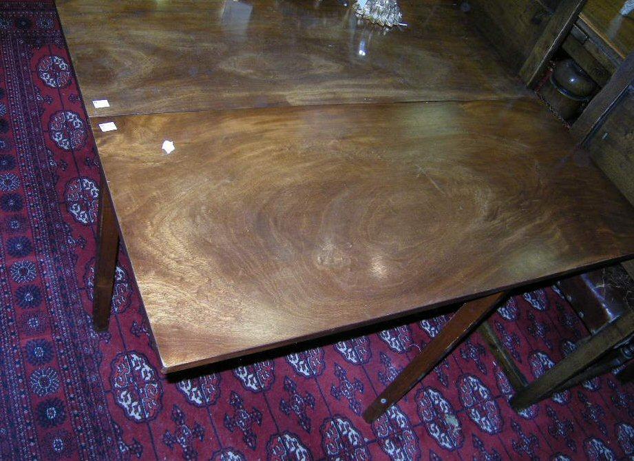 Lot 24 - A George III mahogany drop-flap dining table