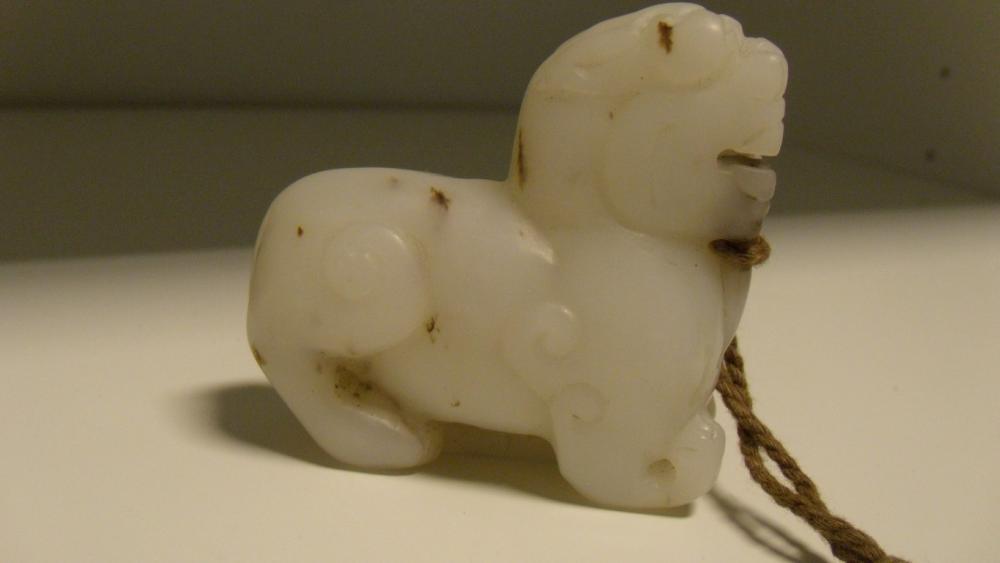 Lot 167 - A Chinese jade reclining qilin pendant,